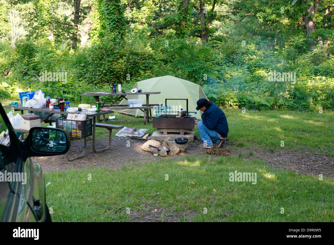 Hispanic man cooking while camping Stock Photo - Alamy