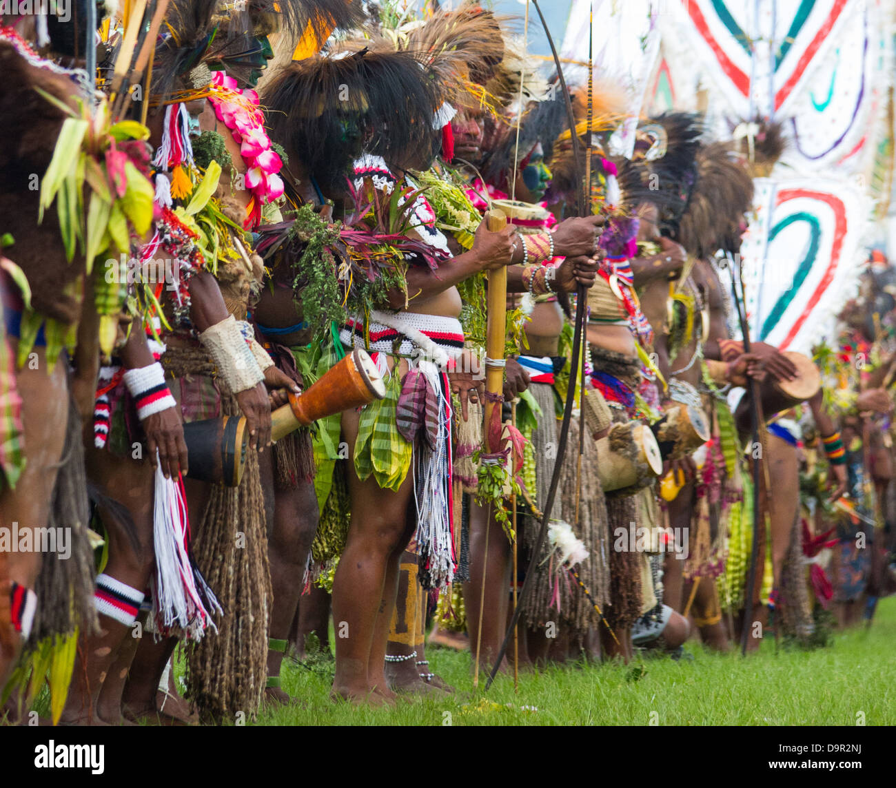 People dressed in traditional tribal outfits and carrying tribal flags ...