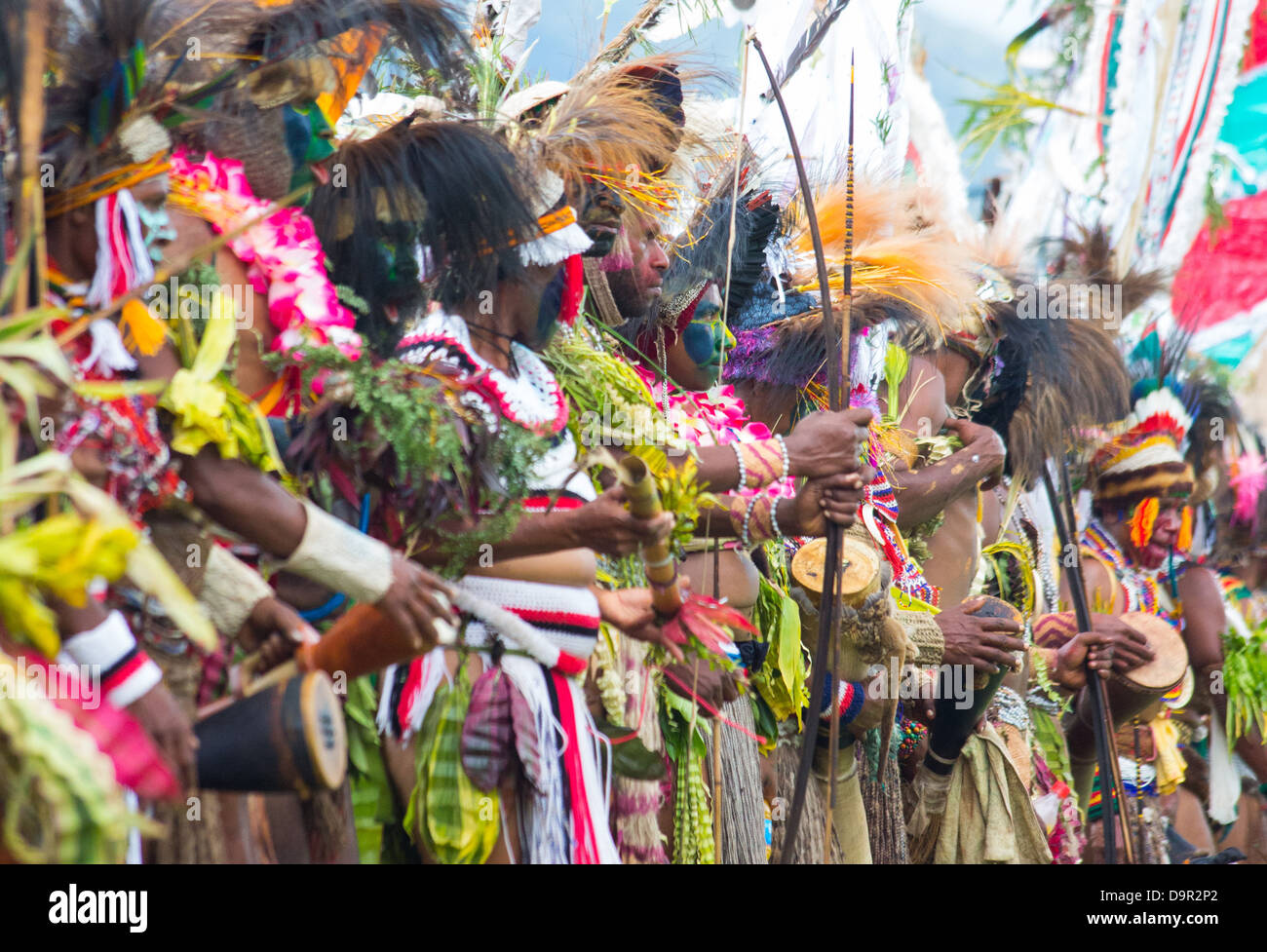 People dressed in traditional tribal outfits and carrying tribal flags ...