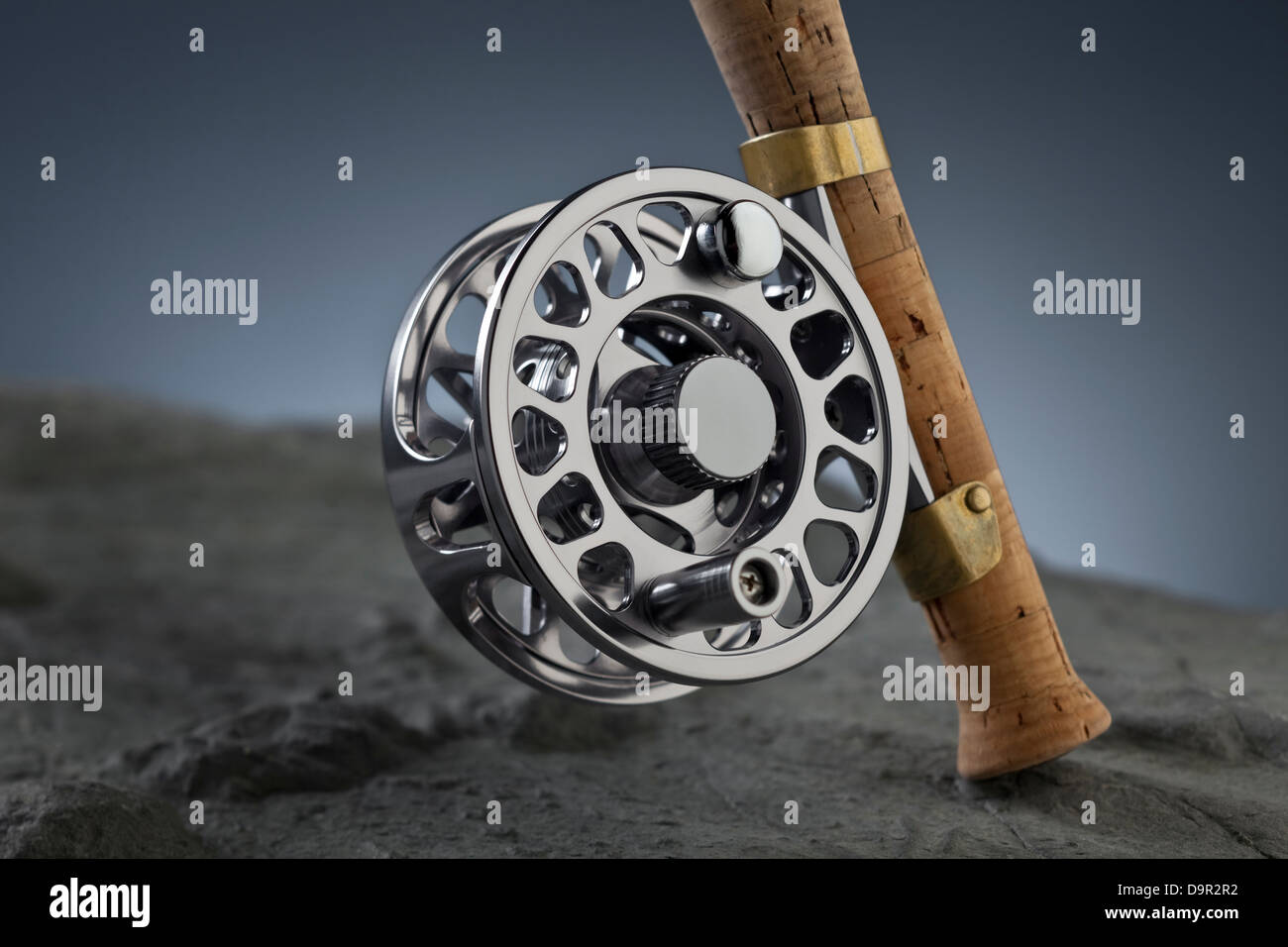 reel fishing rod on a blue background Stock Photo - Alamy