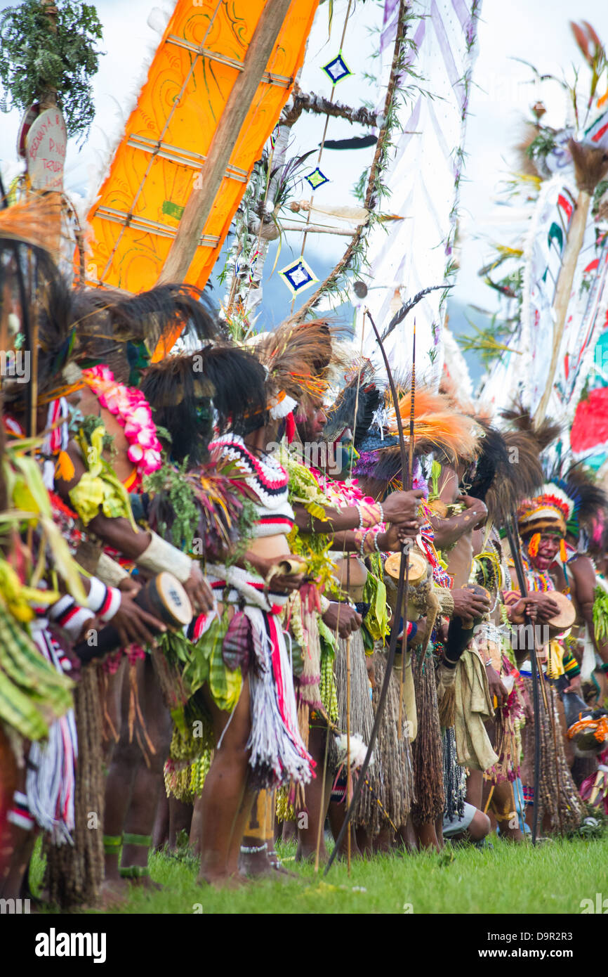 People dressed in traditional tribal outfits and carrying tribal flags ...
