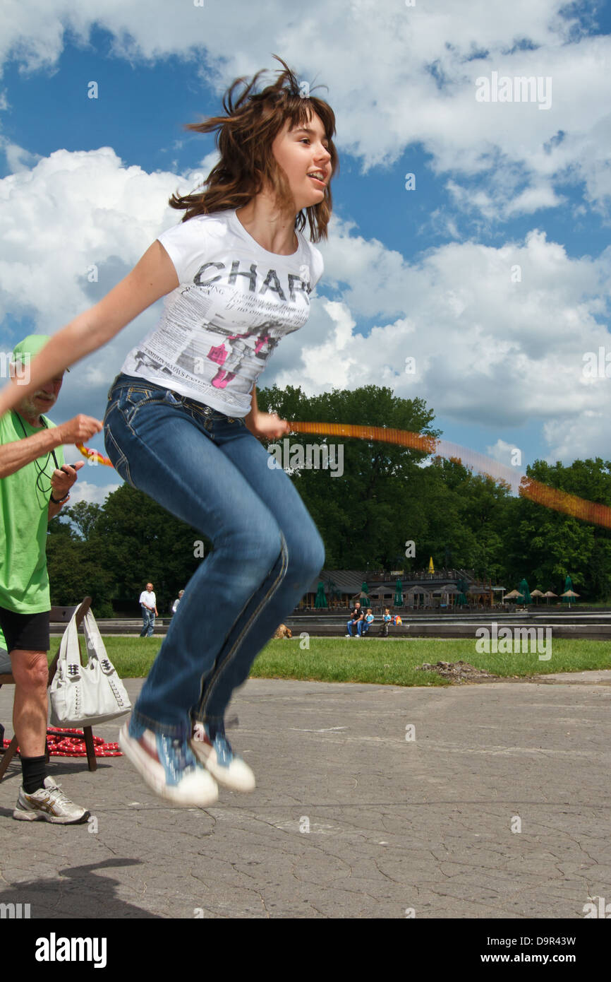 Girl jumping over a skipping rope Stock Photo - Alamy