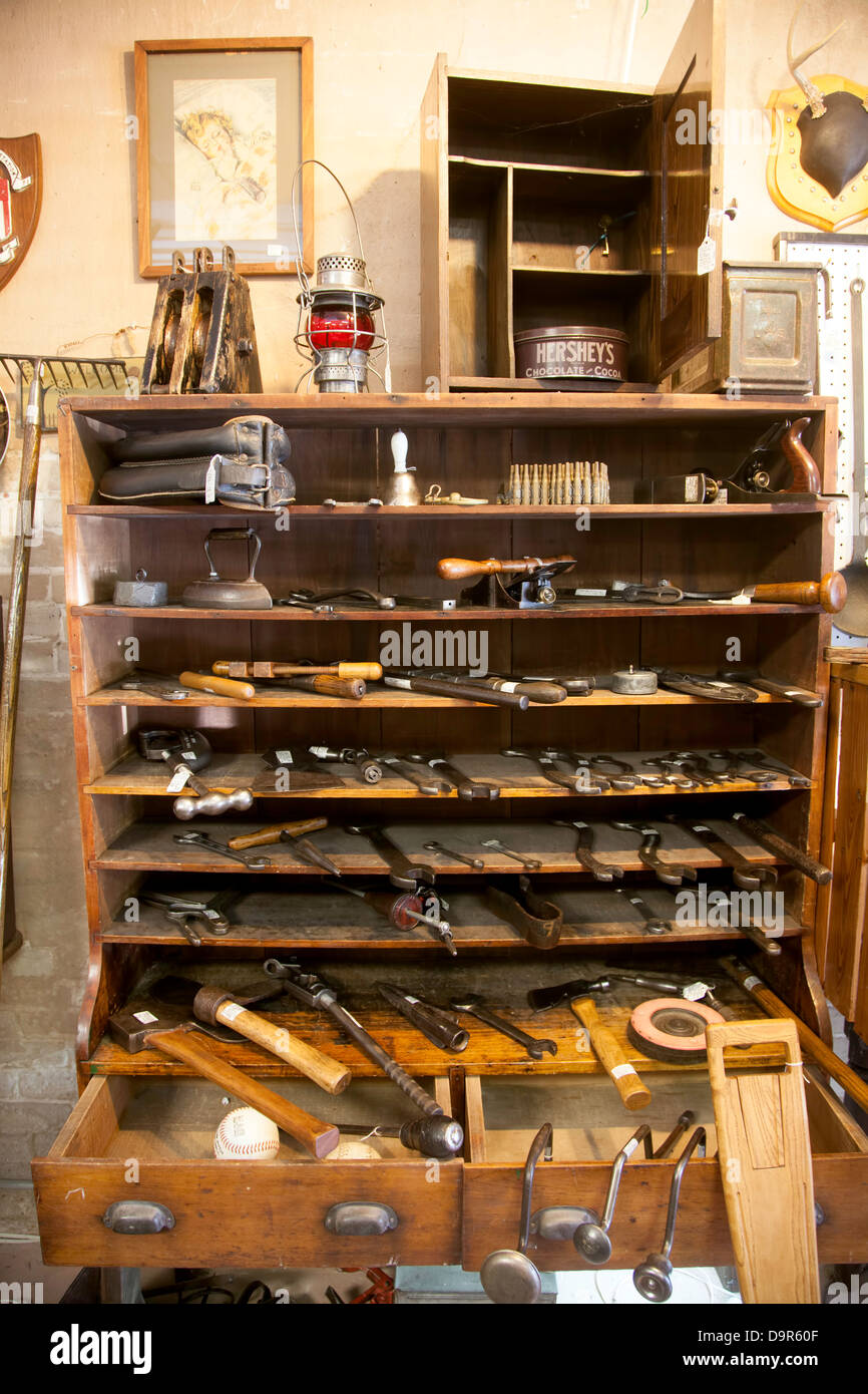 Vintage tools stored in drawers and on wooden racks. Pictures hang on ...