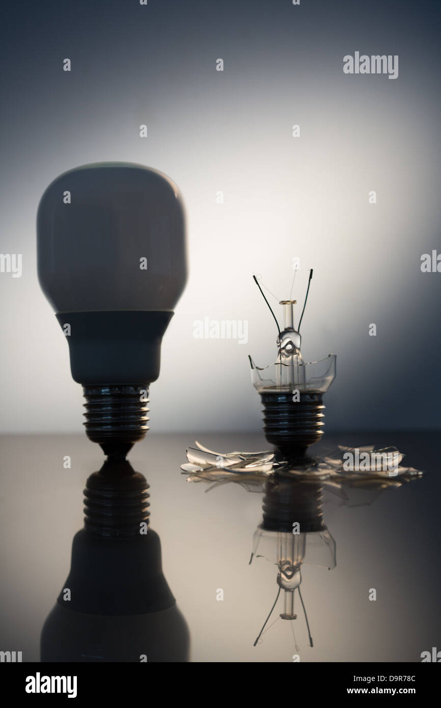 One economic bulb standing next to a broken clear light bulb Stock ...