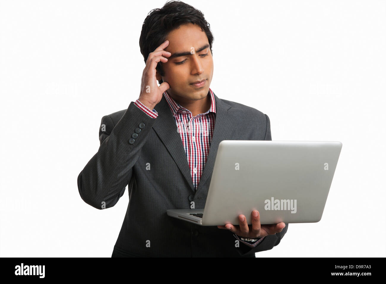Businessman using a laptop and thinking Stock Photo - Alamy