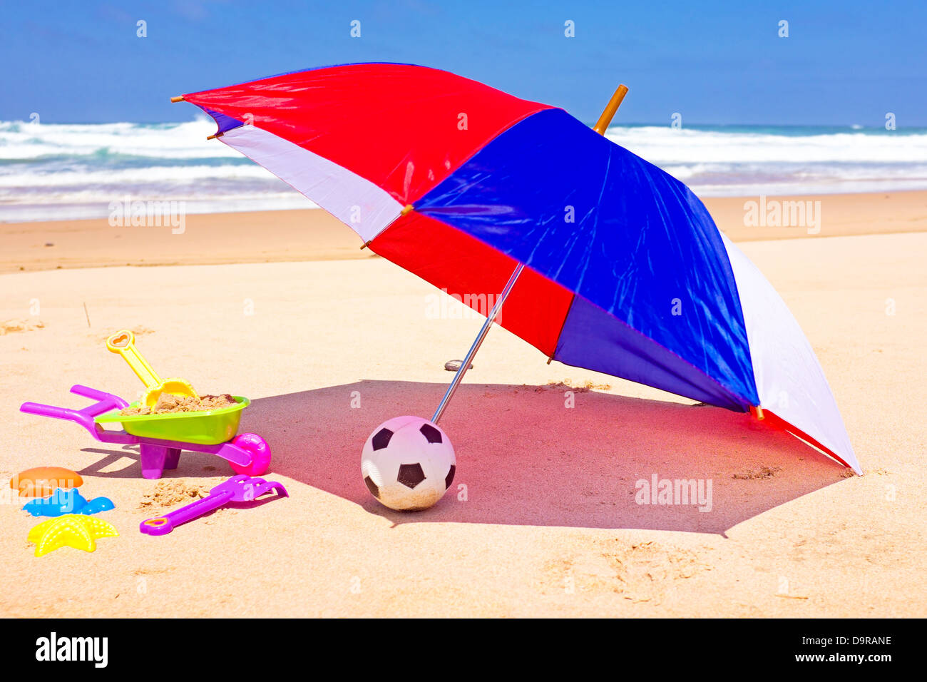 Parasol, toys and ball at the beach hi-res stock photography and images ...