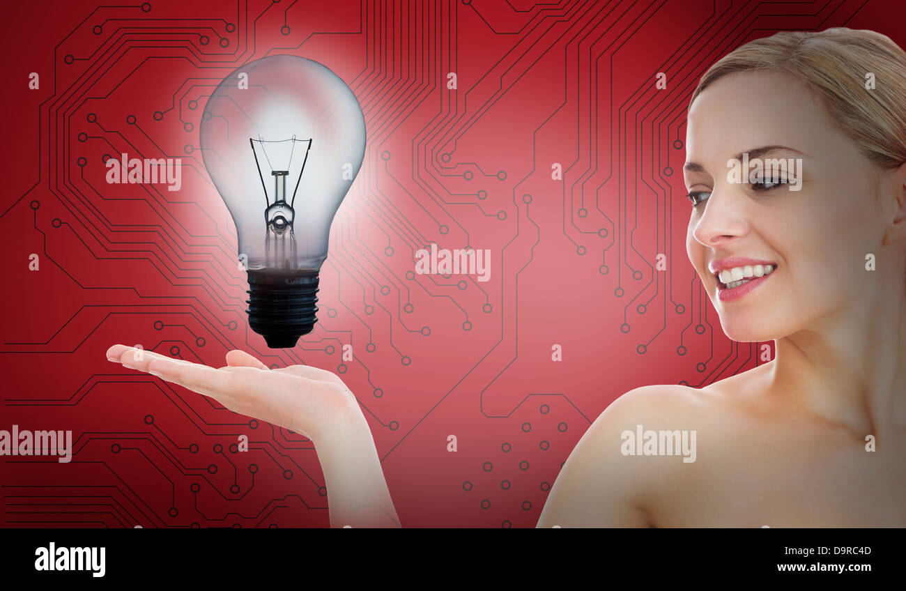 Smiling woman with light bulb inside her hand Stock Photo - Alamy