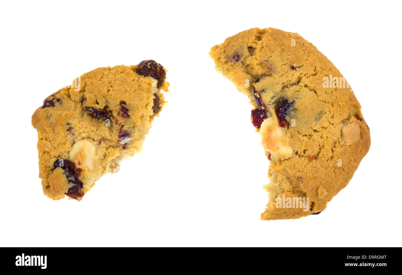 A cranberry white chocolate cookie that is broken in half on a white ...