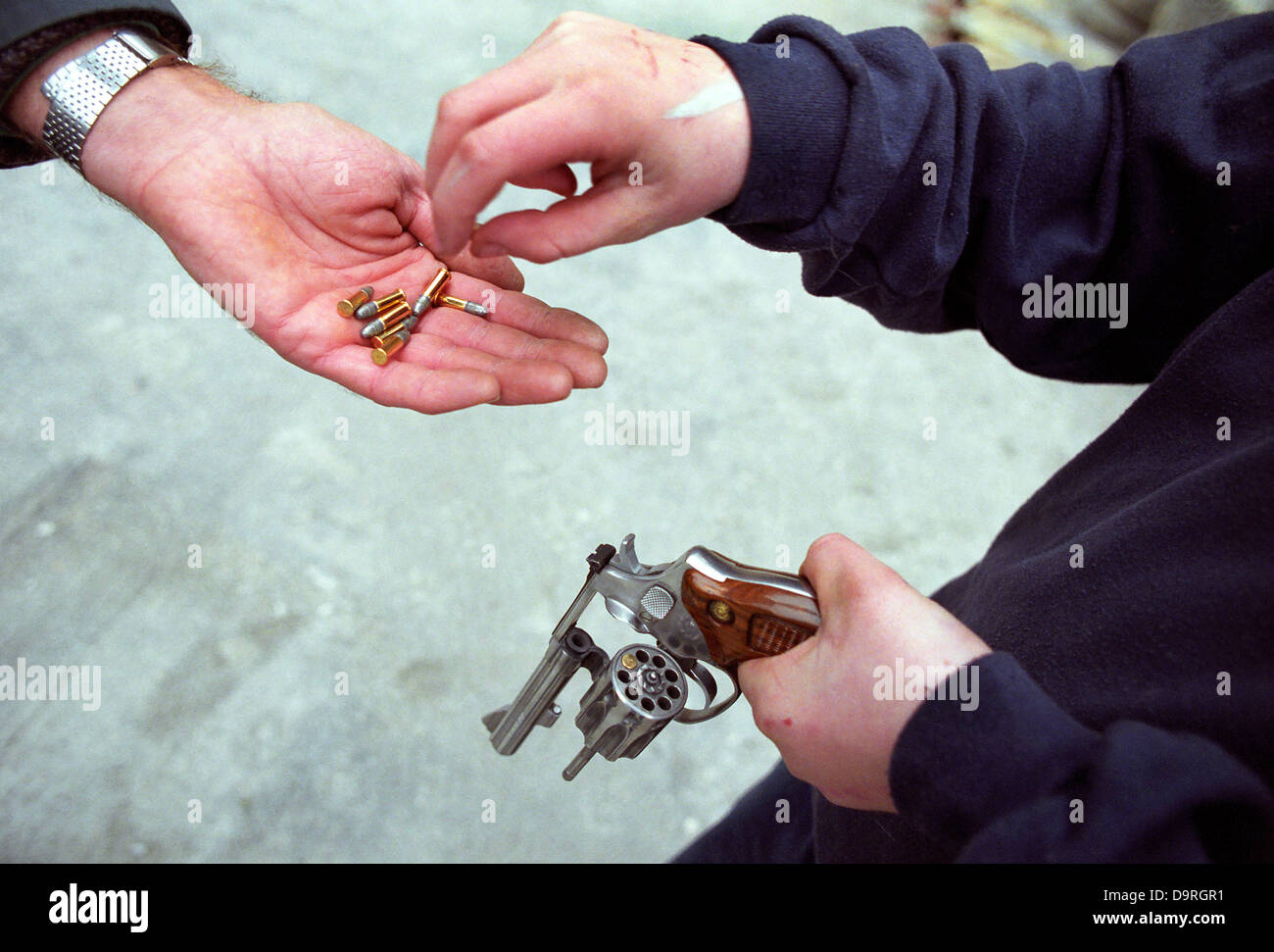 Youngster loading a handgun with bullets Stock Photo - Alamy