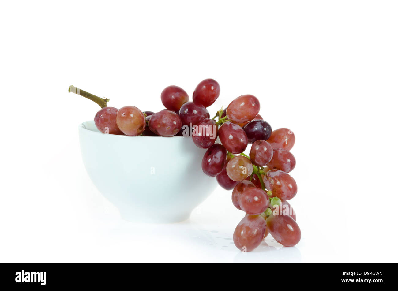 ripe grapes fruits in white bowl over white background Stock Photo - Alamy