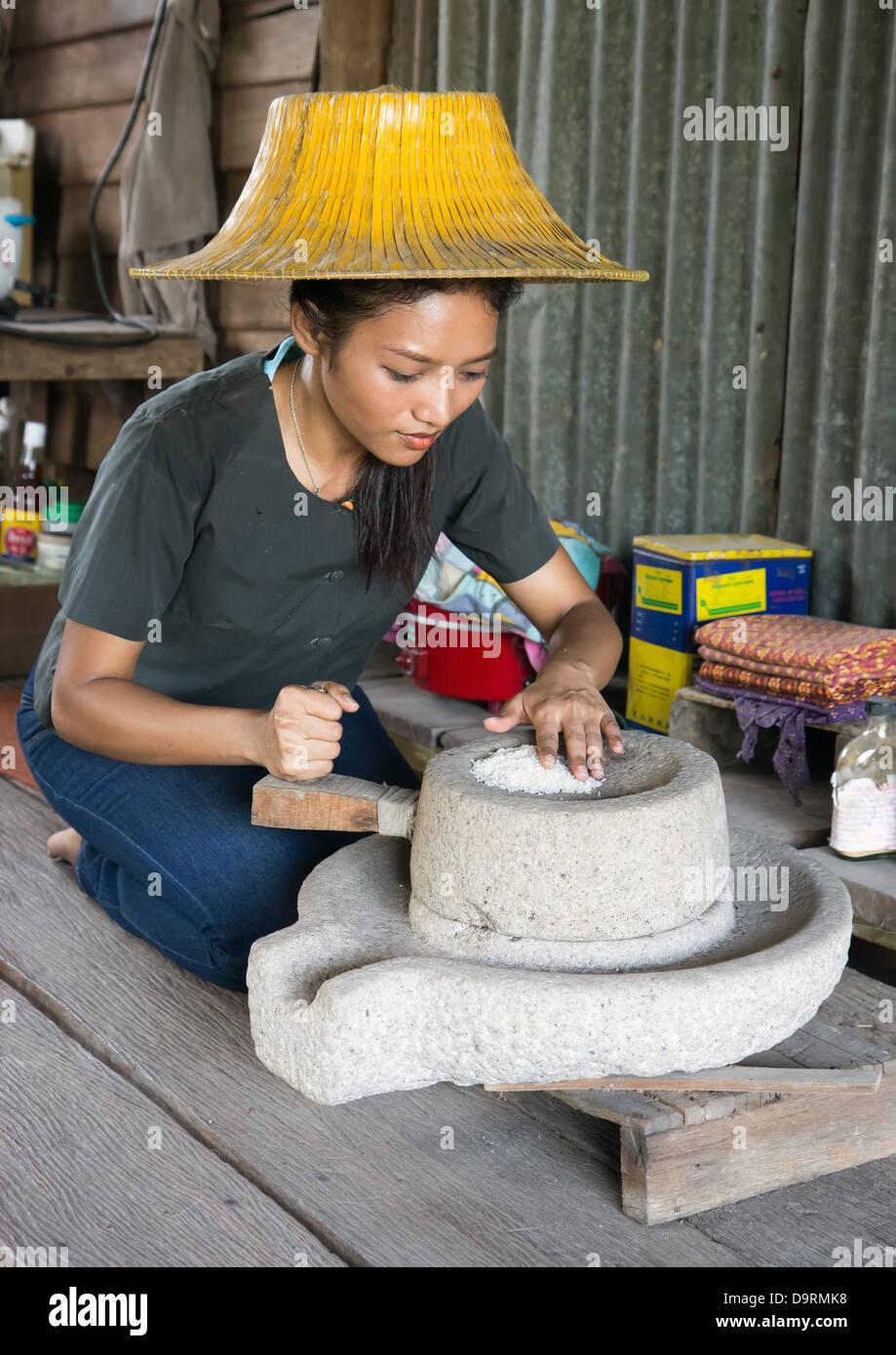 Asian woman mills rice in her home Stock Photo - Alamy