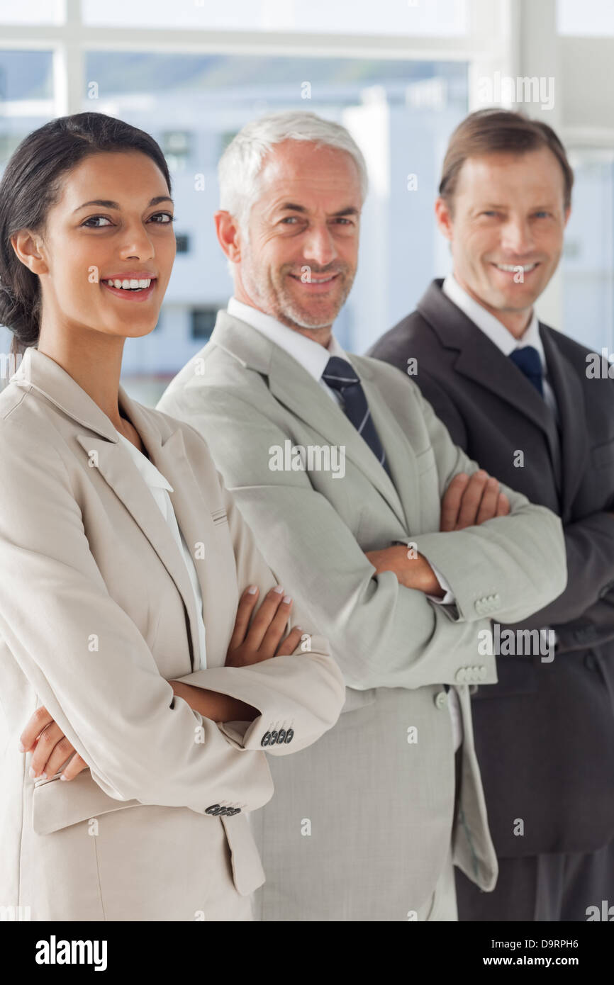 Three smiling business people standing together Stock Photo - Alamy