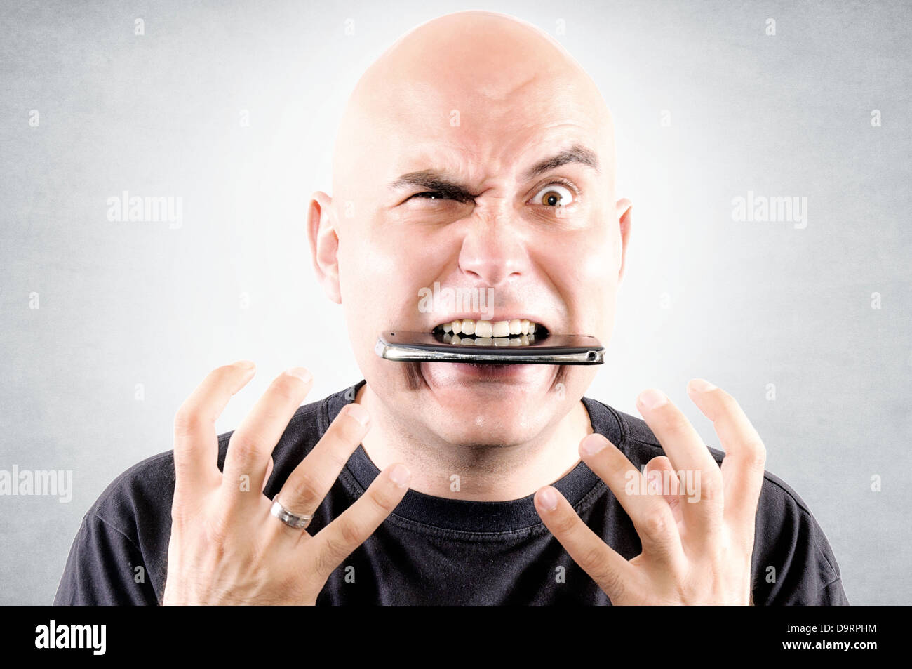 Bald guy eating mobile phone Stock Photo - Alamy