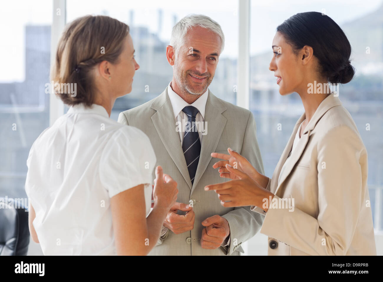 Smiling colleagues discussing together Stock Photo - Alamy