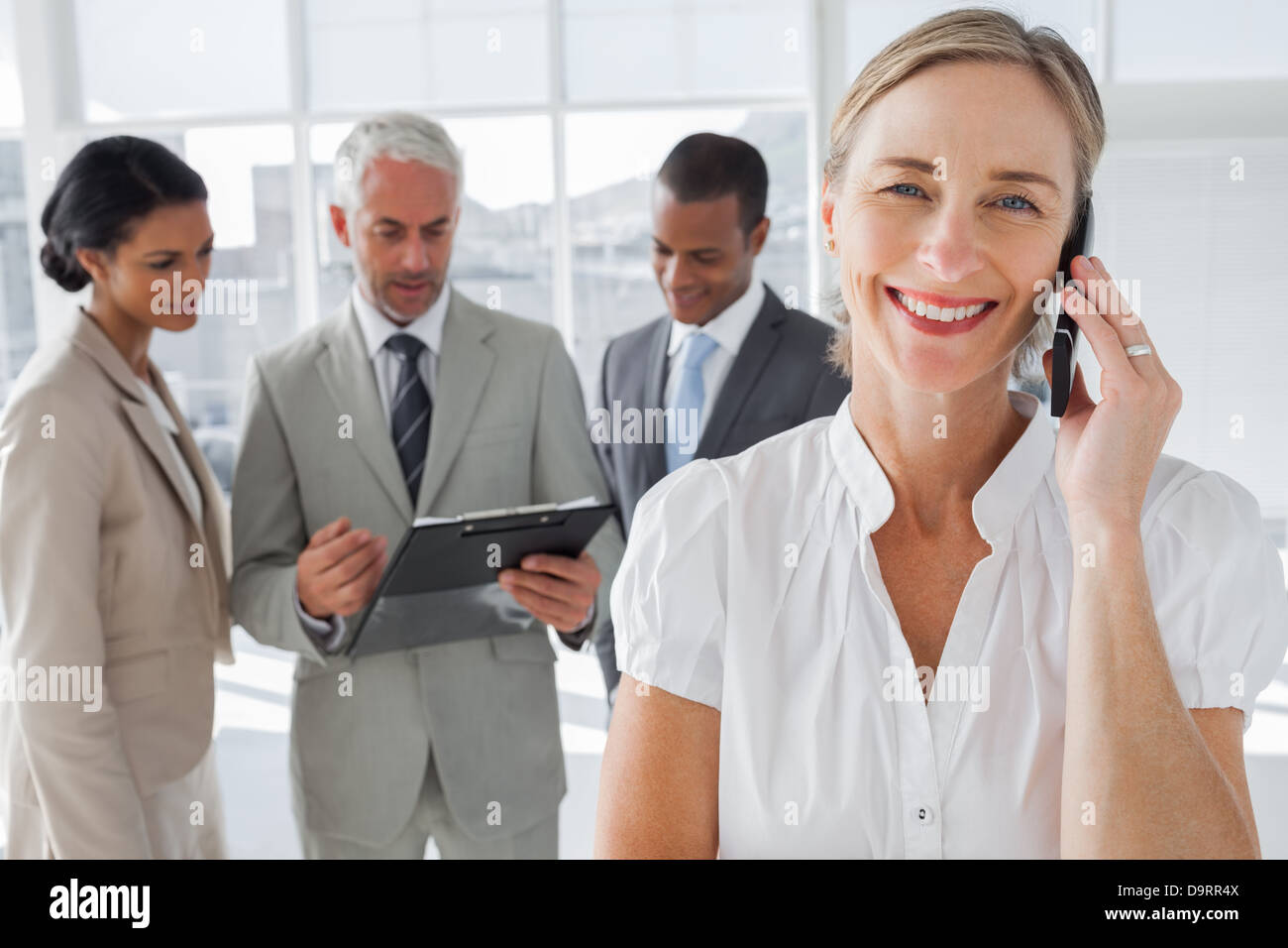 Woman discussing on cellphone holding hi-res stock photography and ...