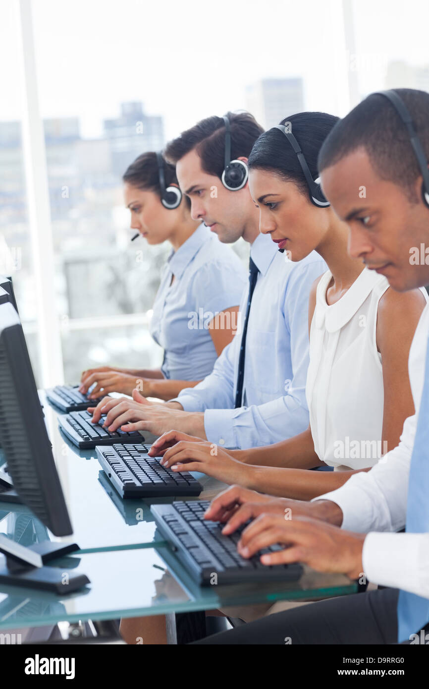 Call center employees sitting in line Stock Photo - Alamy