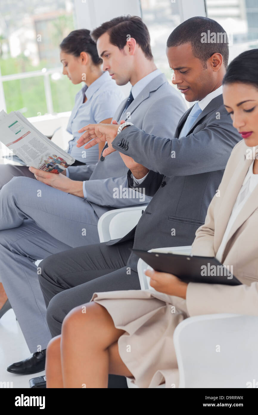 Business people sat in line Stock Photo - Alamy