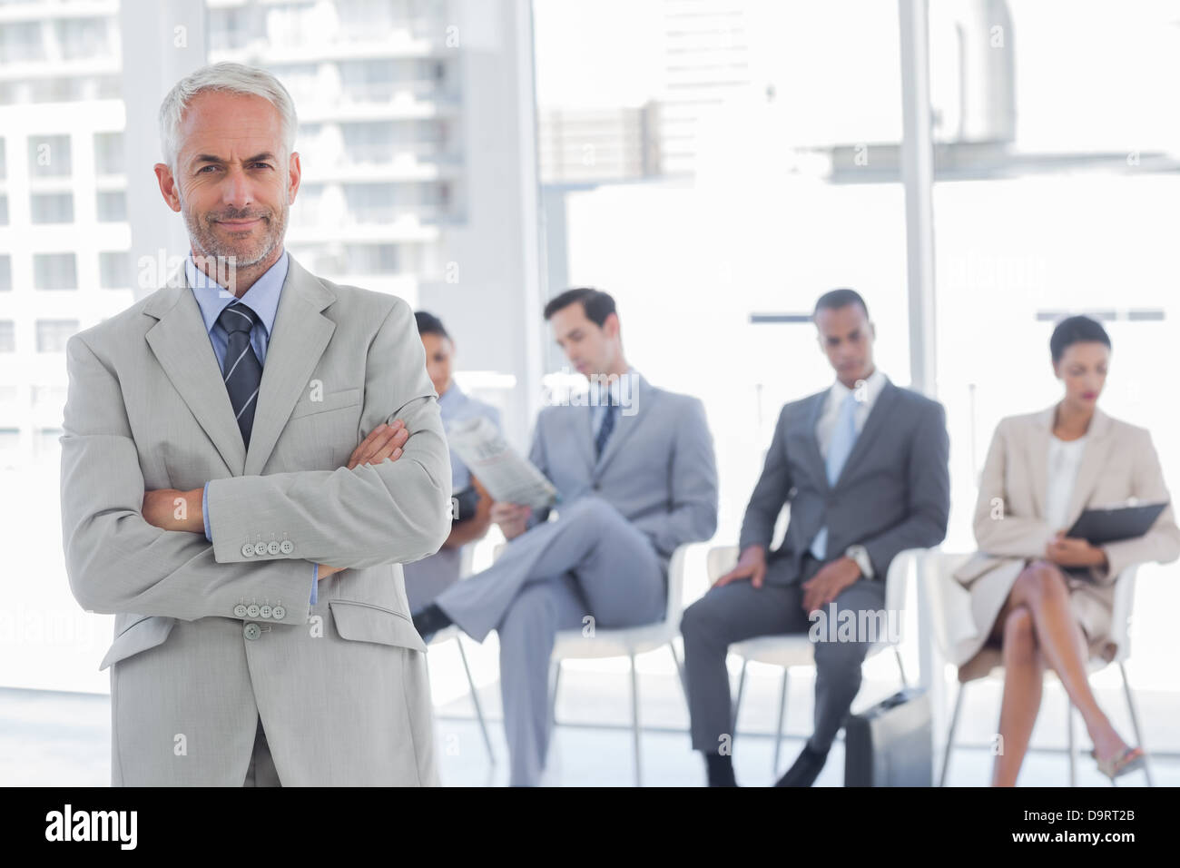 Serious businessman standing in a waiting room Stock Photo - Alamy