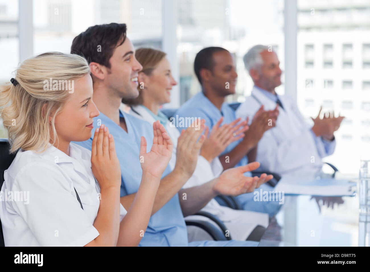 Medical team clapping hands Stock Photo - Alamy