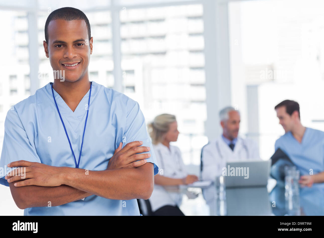 Smiling doctor with arms crossed Stock Photo - Alamy