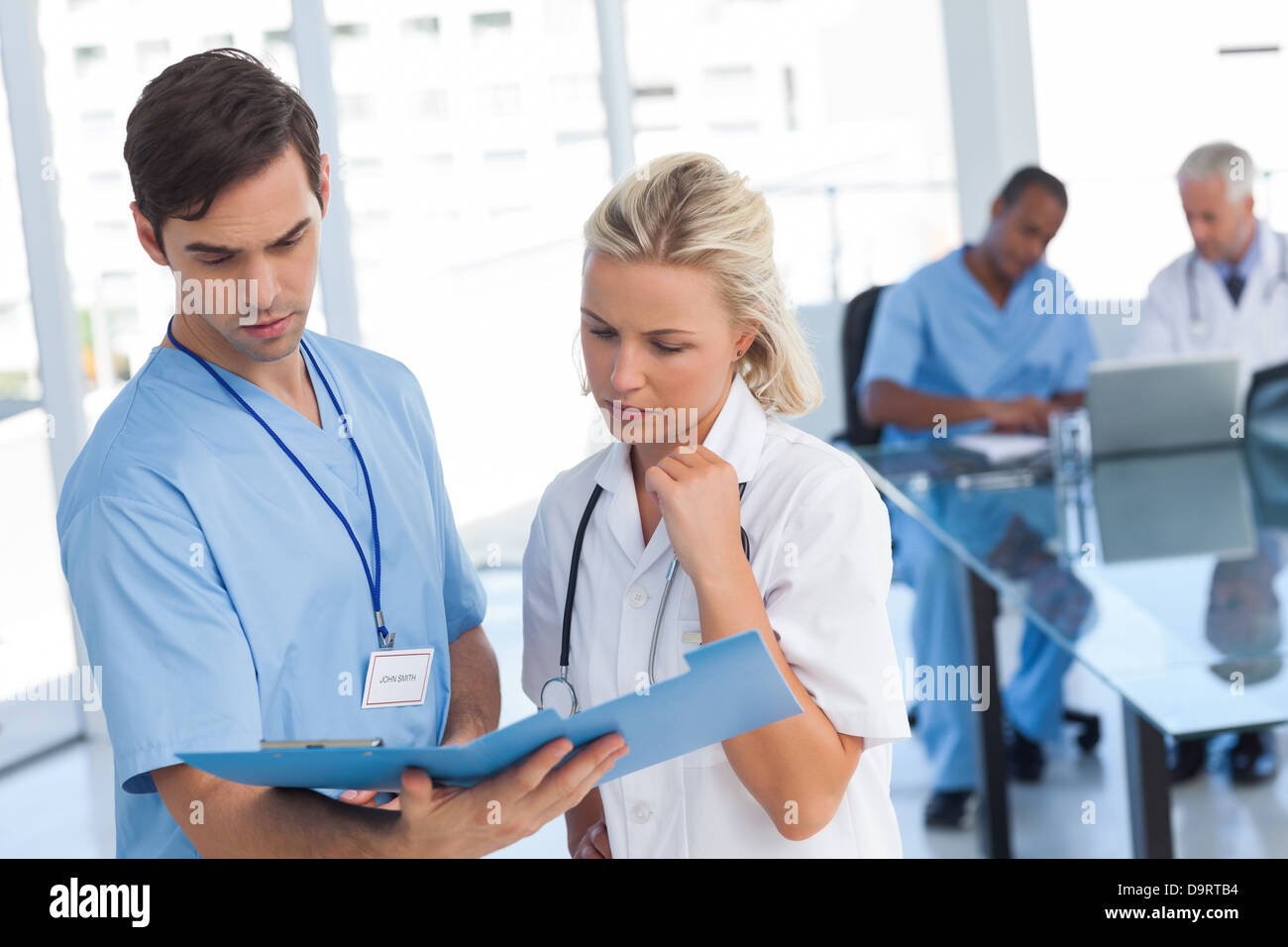 Two doctors examining a file Stock Photo - Alamy