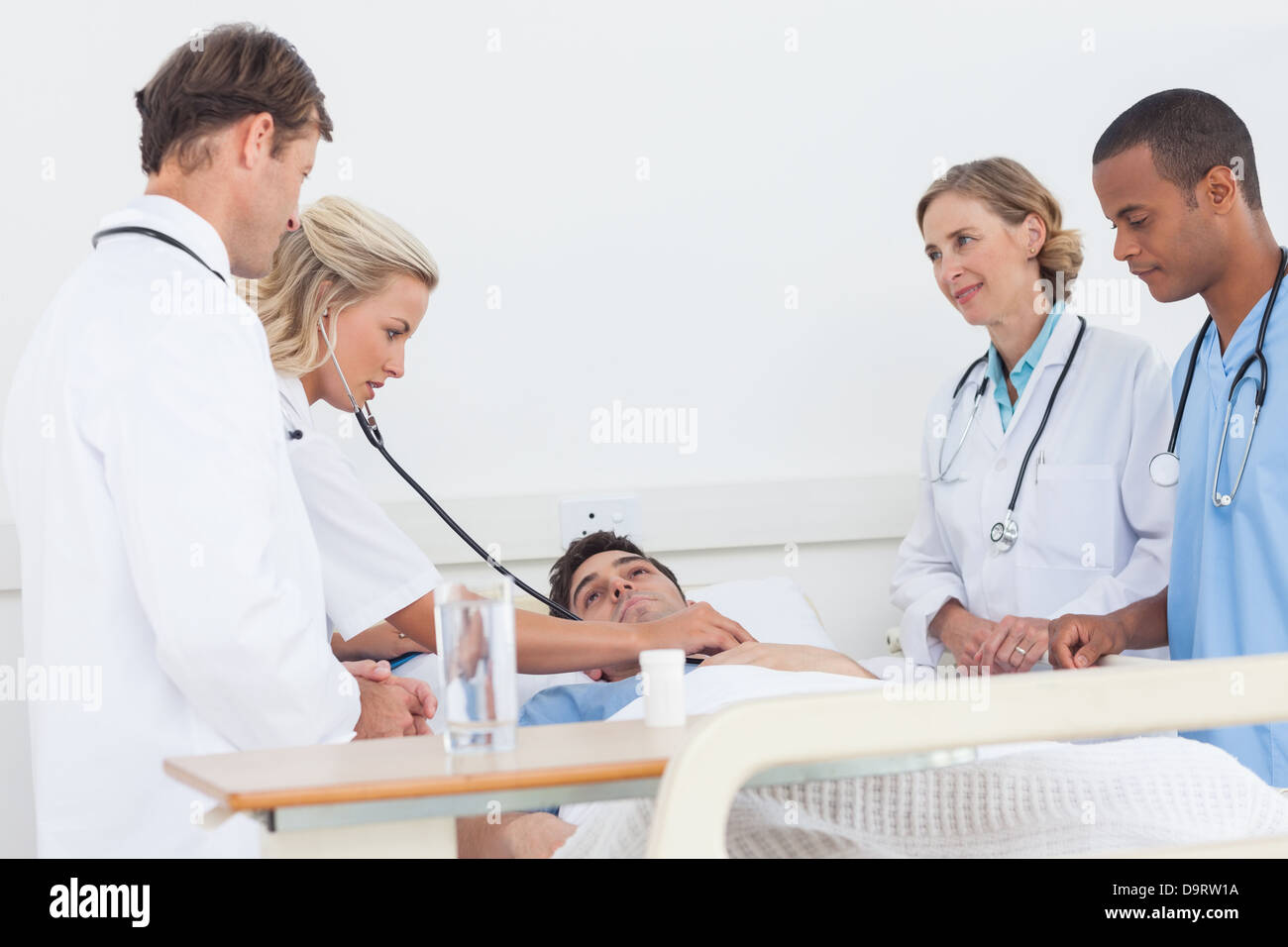 Medical team taking the heartbeat of a patient Stock Photo - Alamy