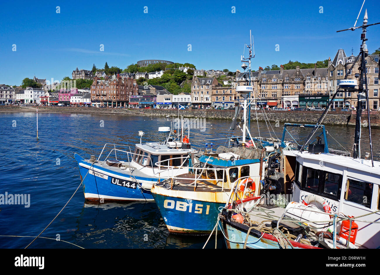 Fishing boats lined up in Oban harbour Scotland with the famous McCaig ...