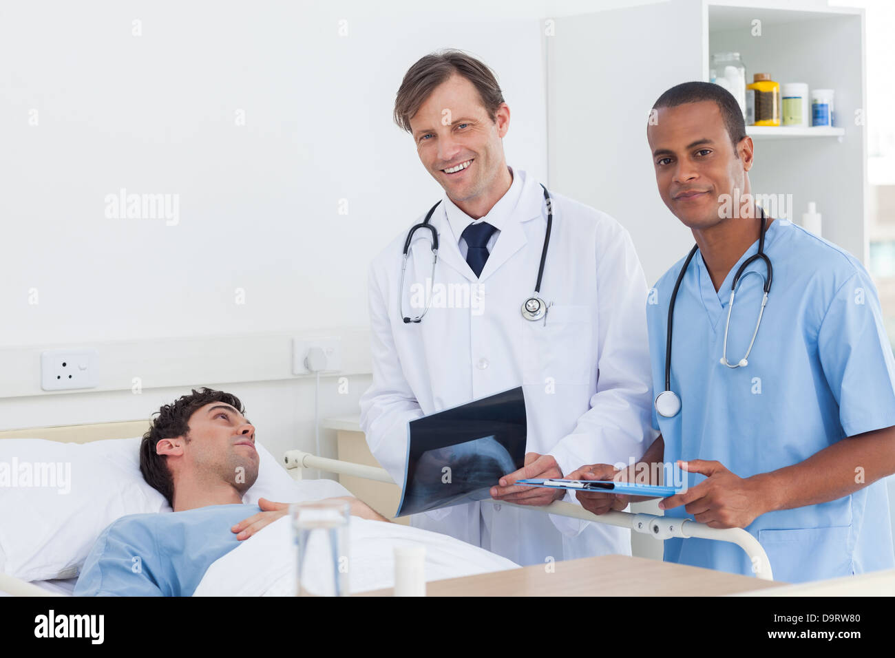 Doctors with radiography standing next to a patient Stock Photo - Alamy