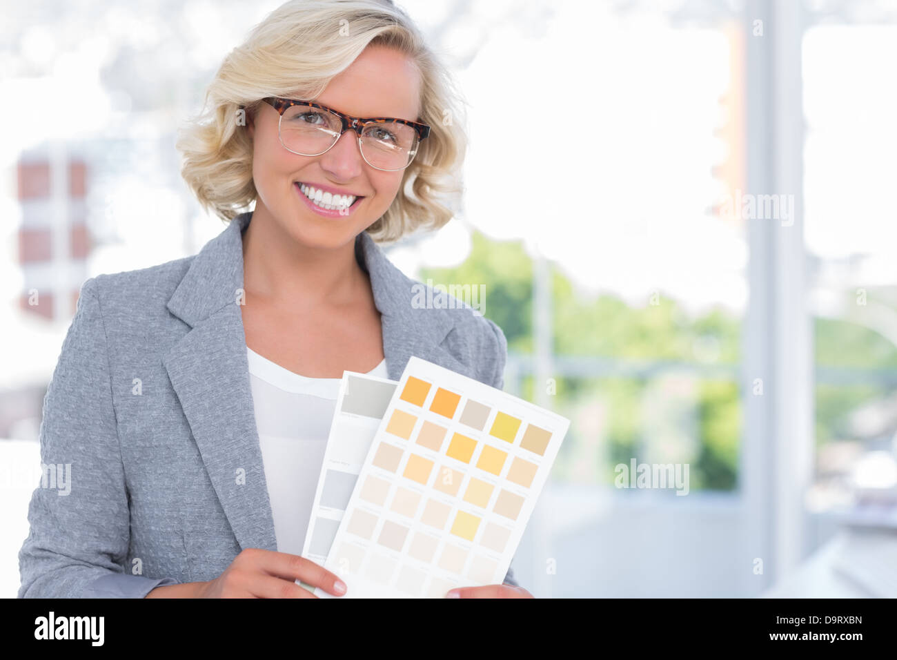 Pretty interior designer holding up colour samples Stock Photo - Alamy
