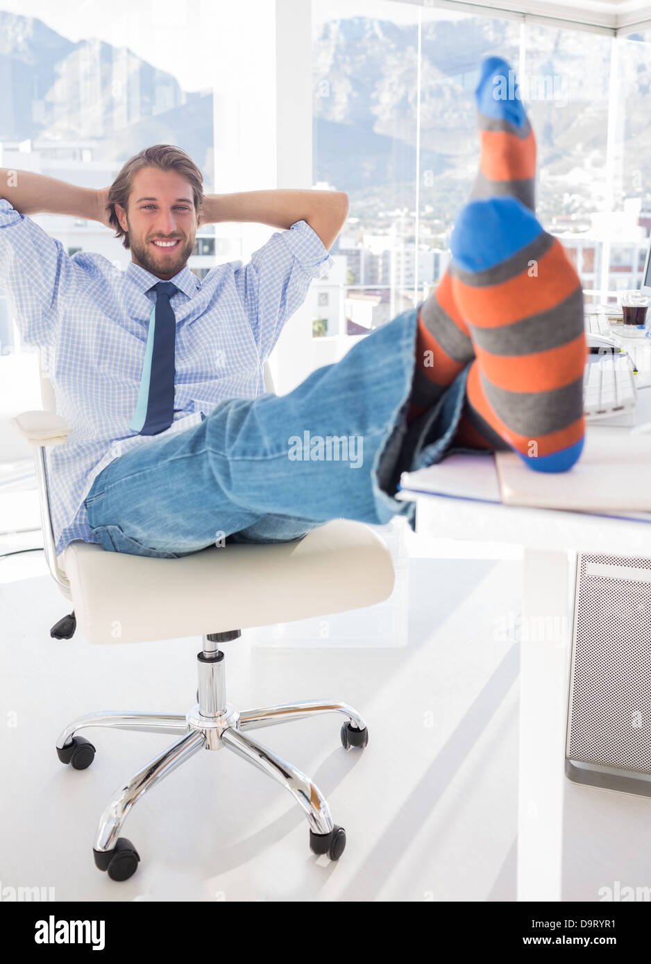 Shoeless designer kicking back Stock Photo - Alamy