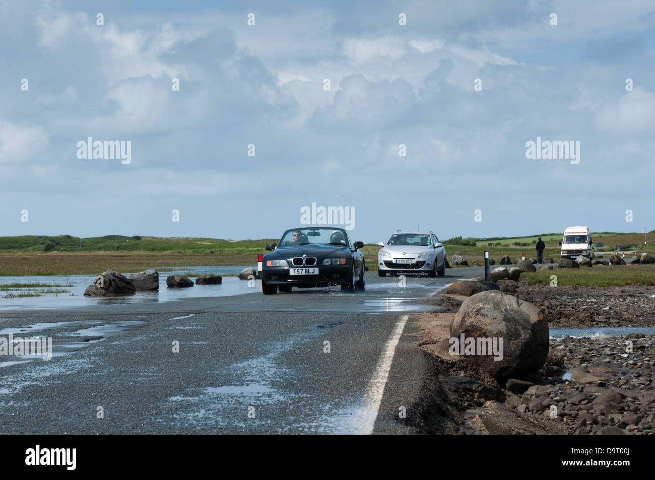 Cars and people cross to Shell Island over a tidal causeway Stock Photo ...