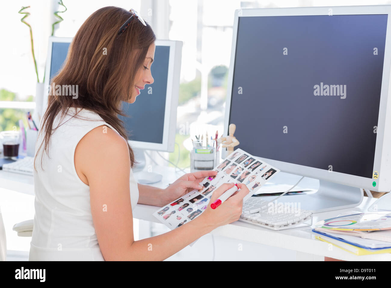 Photo editor working on contact sheet Stock Photo - Alamy