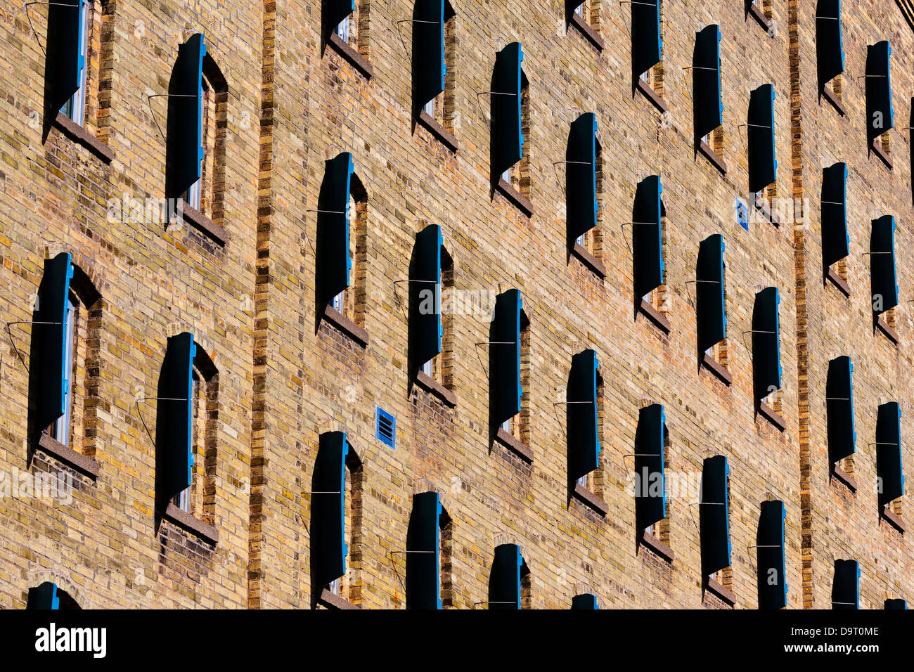 Brick building with rows of small shutter windows Stock Photo - Alamy