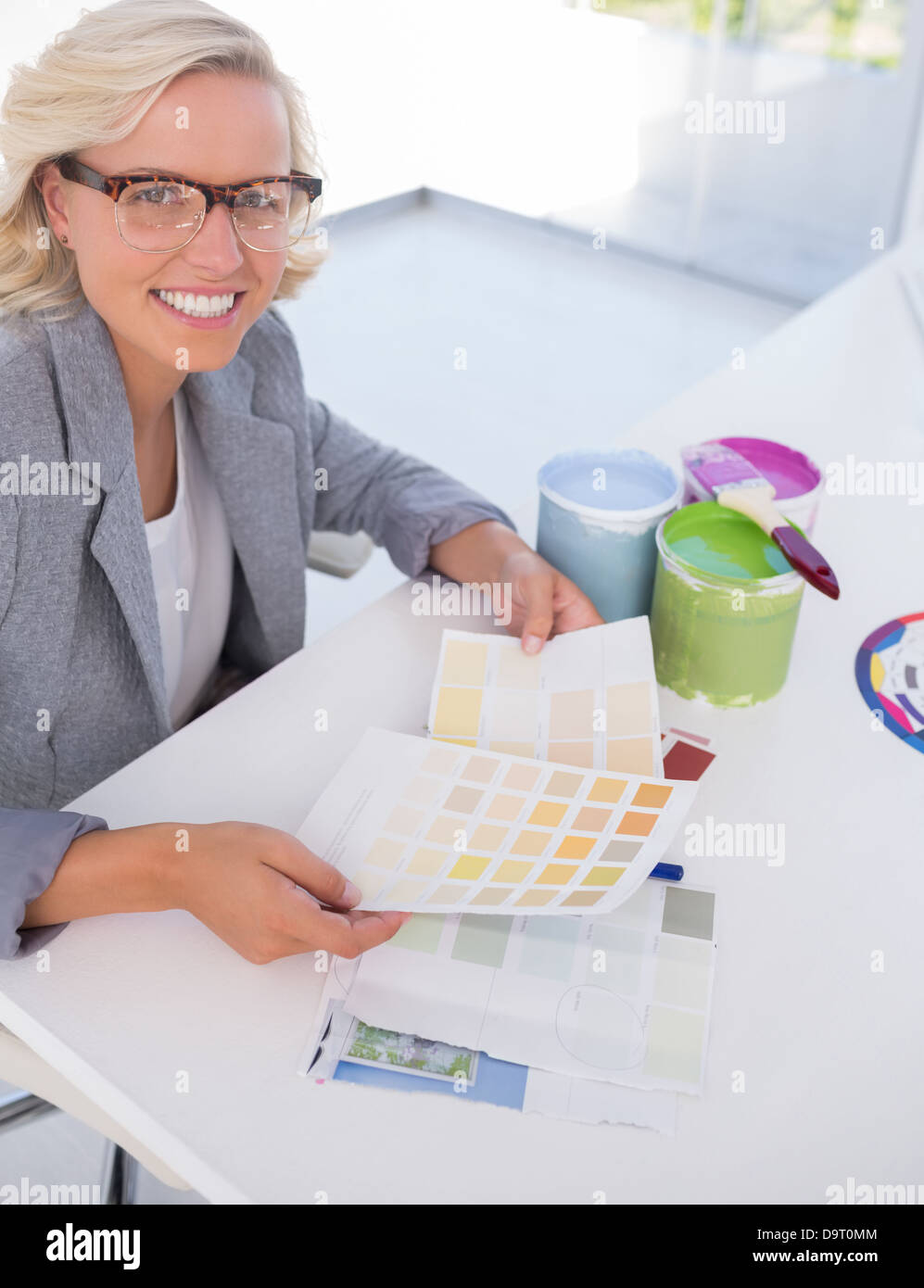 Cheerful blonde interior designer holding colour charts Stock Photo - Alamy