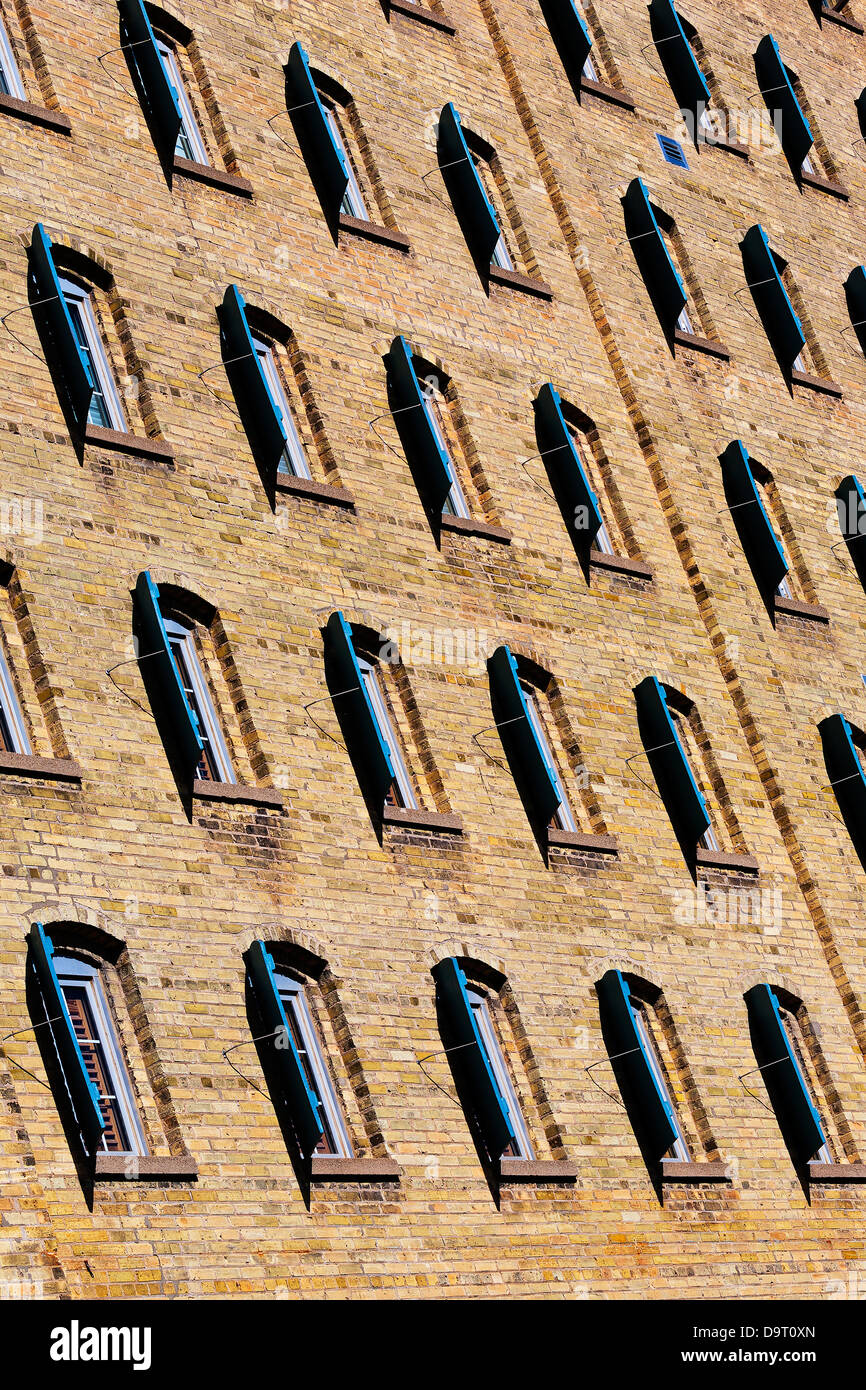 Brick building with rows of small shutter windows Stock Photo - Alamy