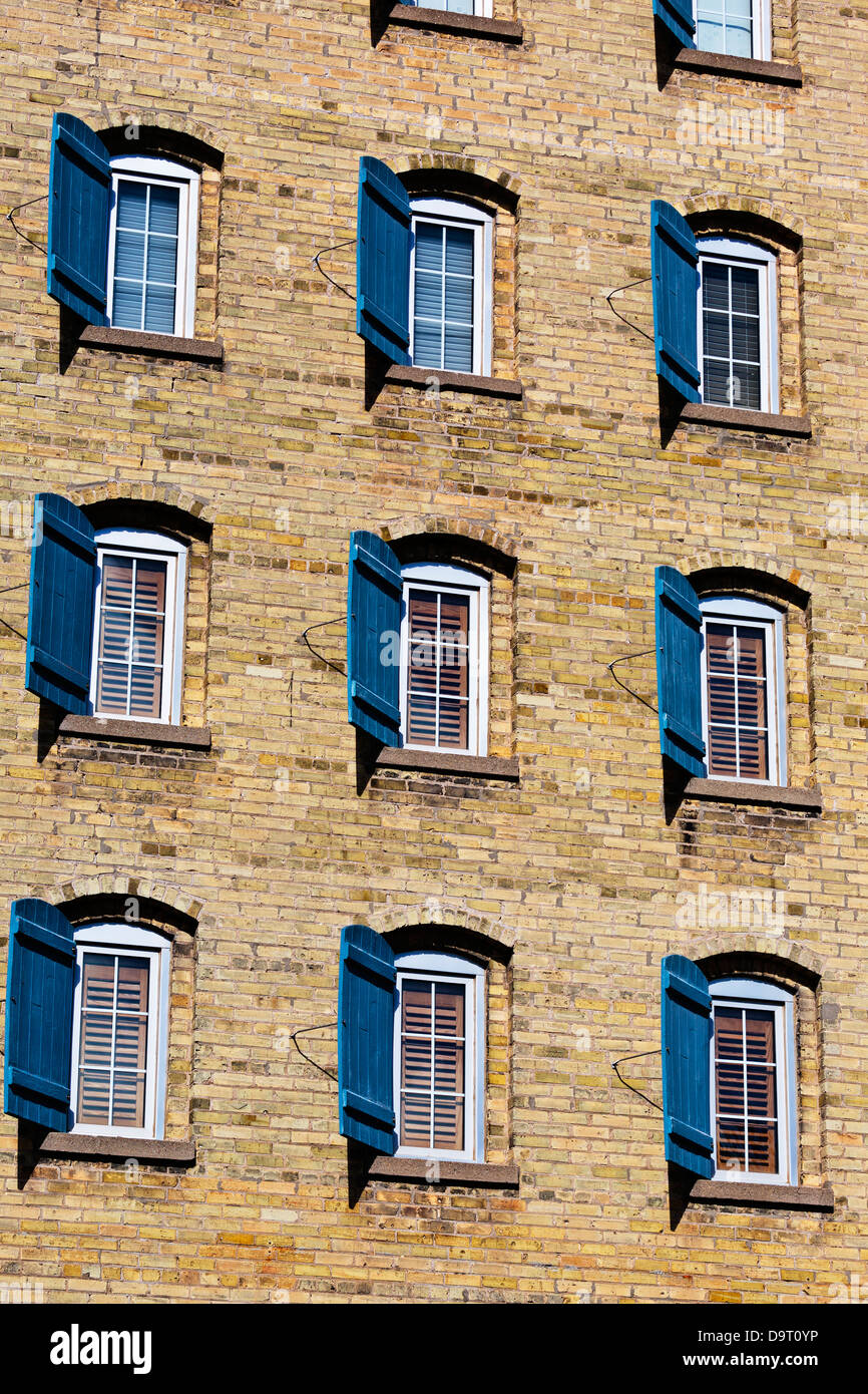 Brick building with rows of small shutter windows Stock Photo - Alamy
