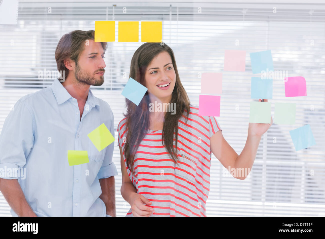 Young man and woman brainstorming together Stock Photo - Alamy