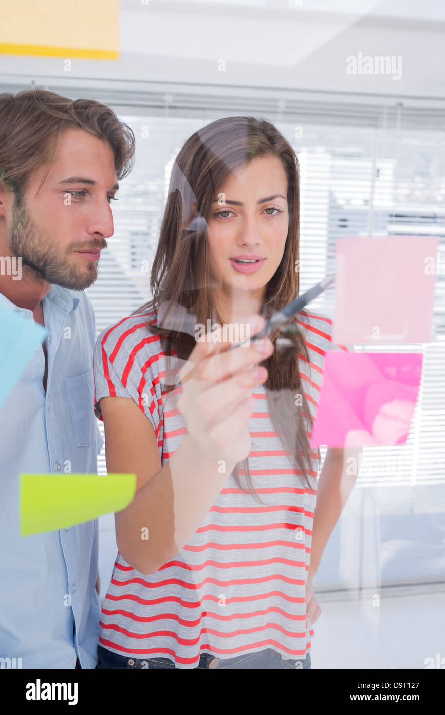 Woman showing sticky note to her colleague Stock Photo - Alamy