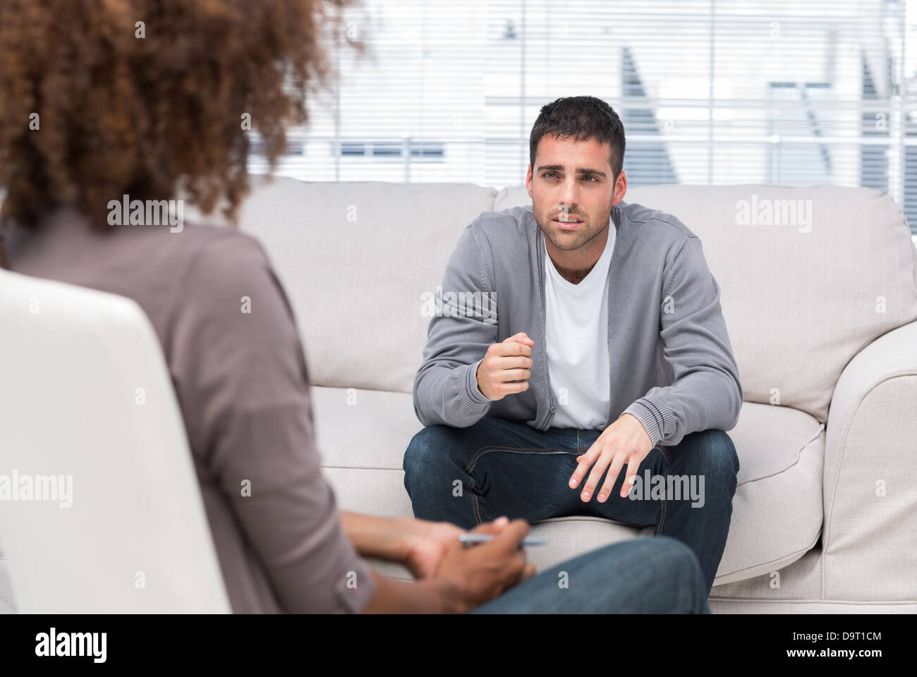 Sad man speaking to a therapist Stock Photo - Alamy