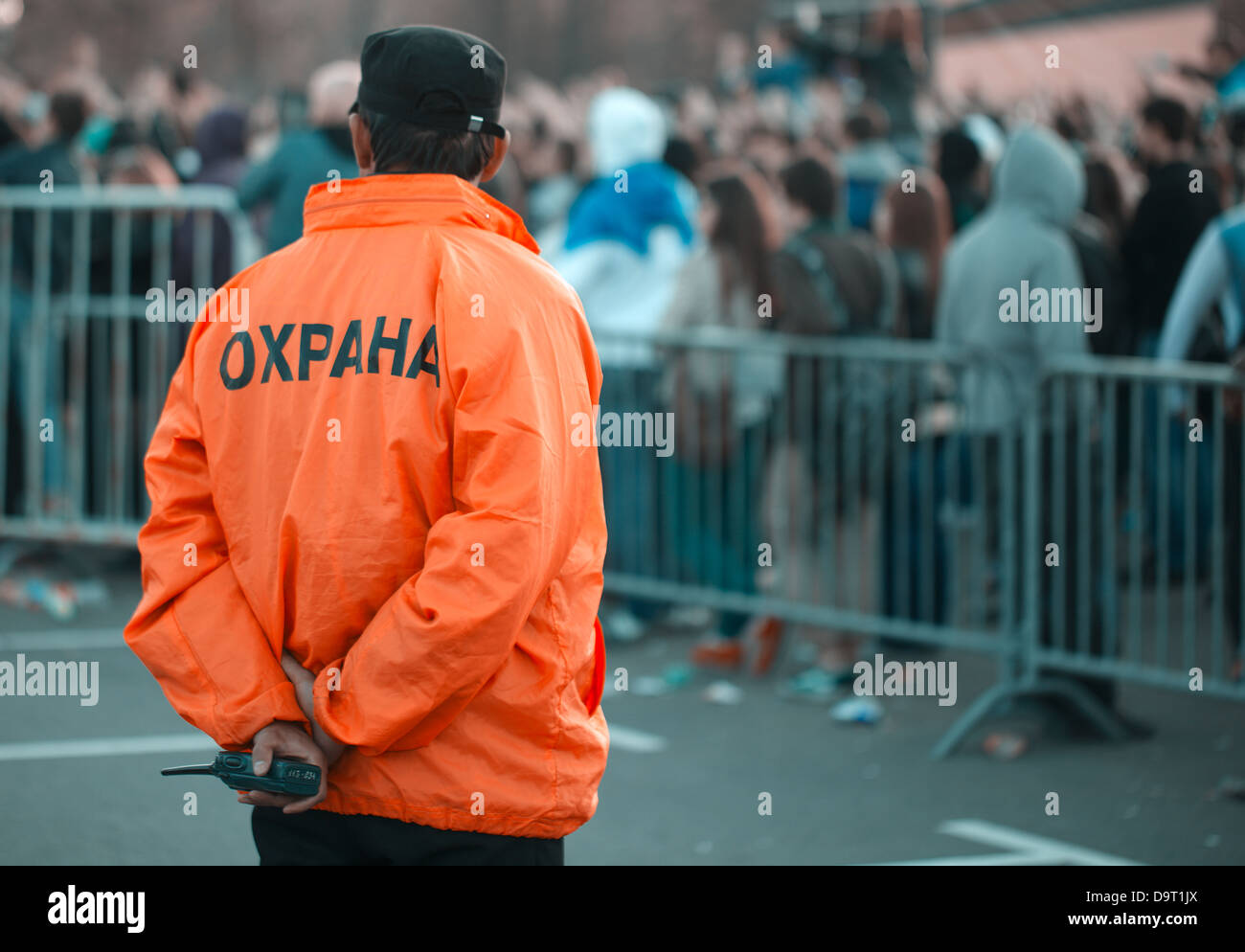 Back security guard in front of blurred crowd Stock Photo - Alamy