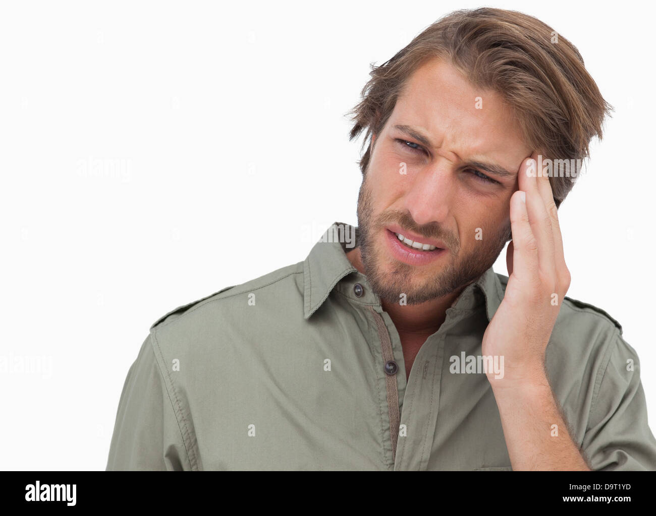 Man with headache looking away and wincing Stock Photo - Alamy