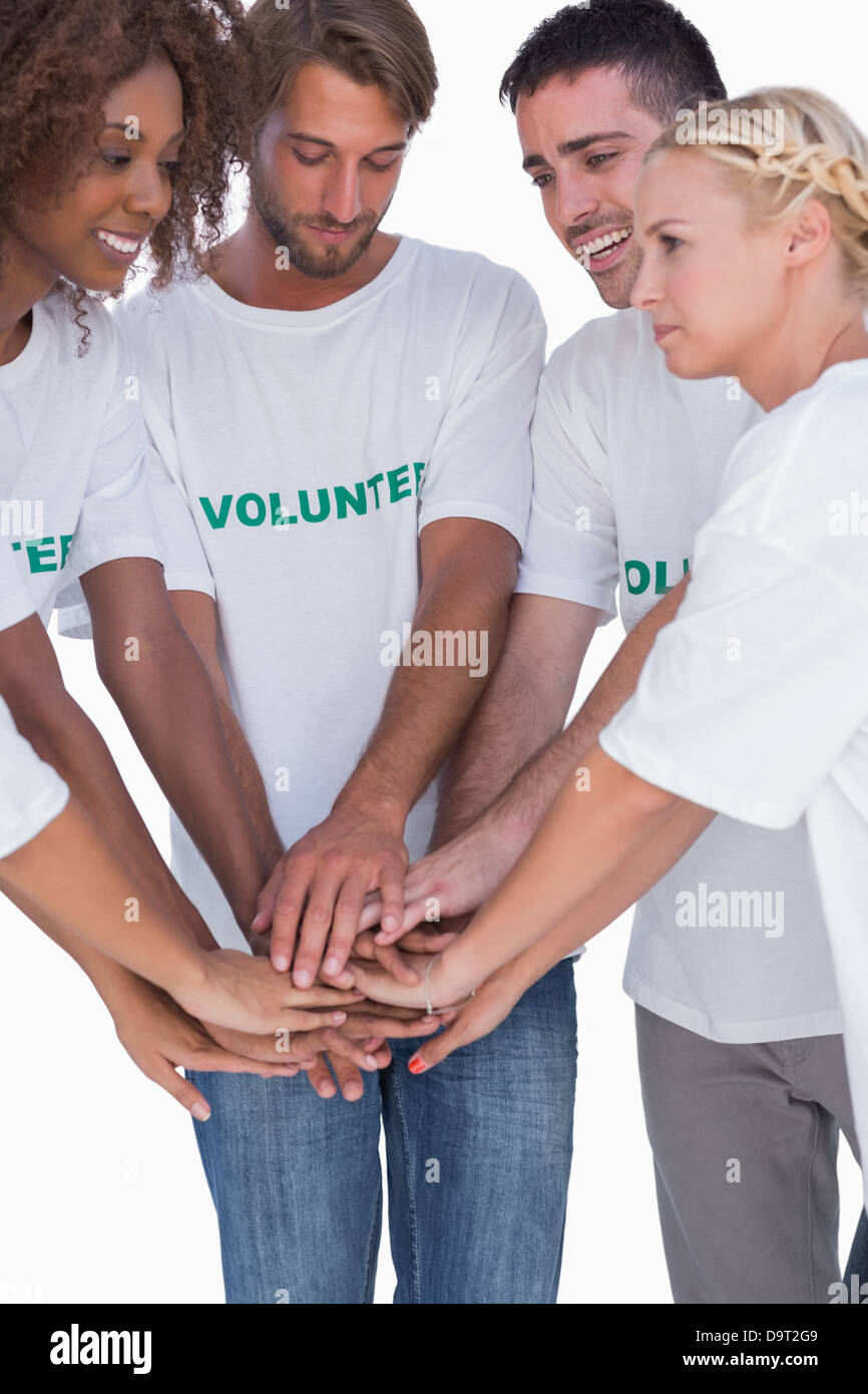 Smiling volunteers putting hands together Stock Photo - Alamy
