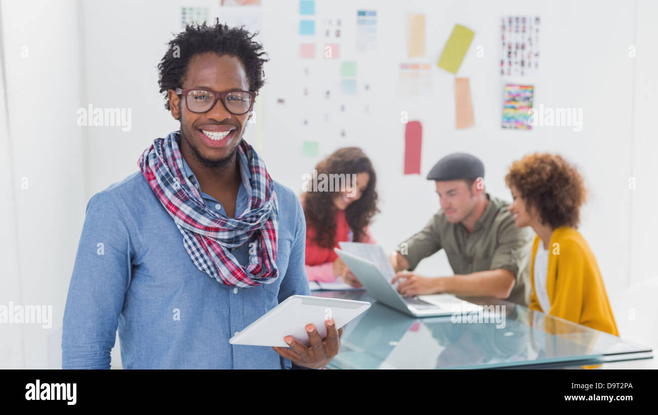 Designer standing and smiling with his tablet Stock Photo - Alamy