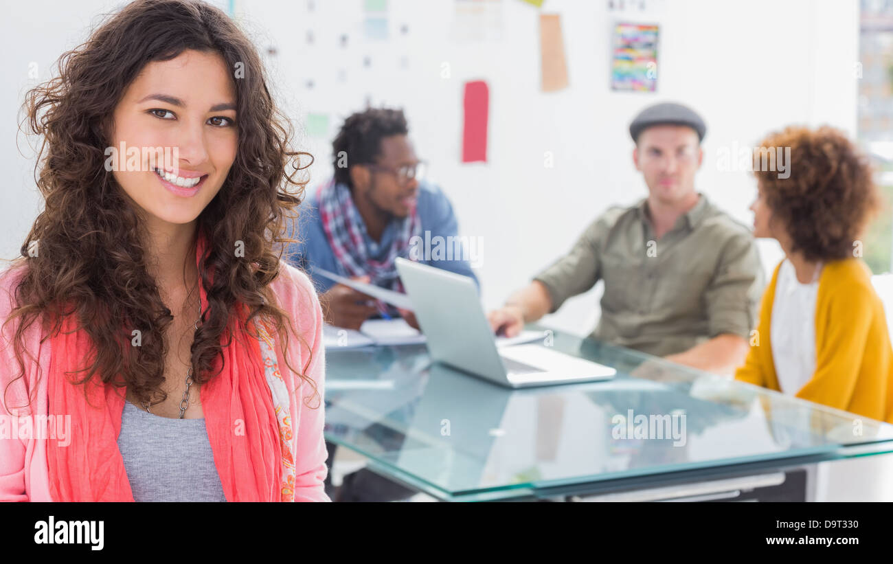 Smiling woman with creative team working behind Stock Photo - Alamy