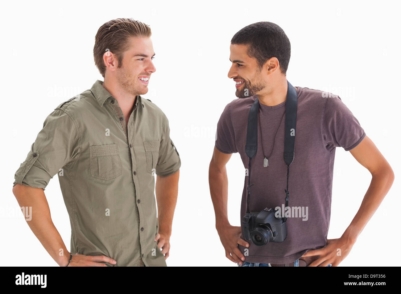 Stylish friends smiling at each other with one holding camera Stock ...