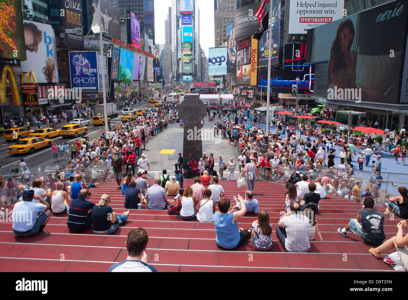 CROWD SITTING ON RED STEPS TKTS CENTER TIMES SQUARE MIDTOWN MANHATTAN ...