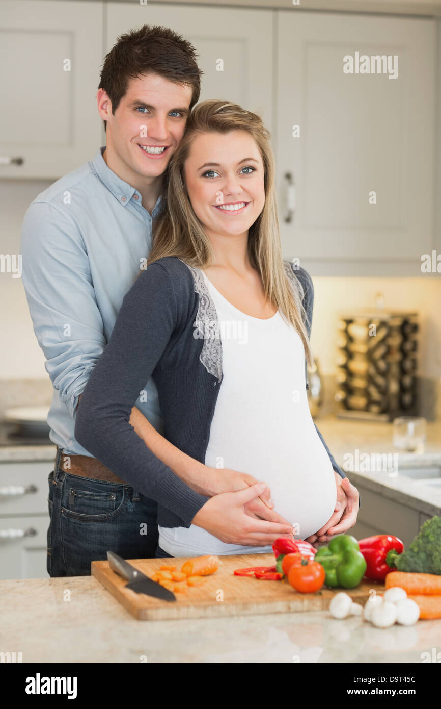 Pregnant woman and huband stand behind kitchen counter Stock Photo - Alamy
