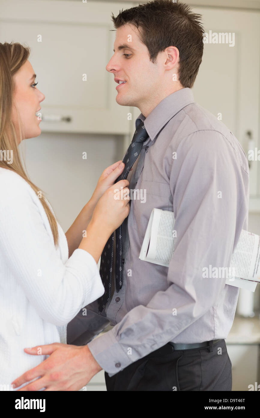 Woman talking with her husband and fixing tie Stock Photo - Alamy