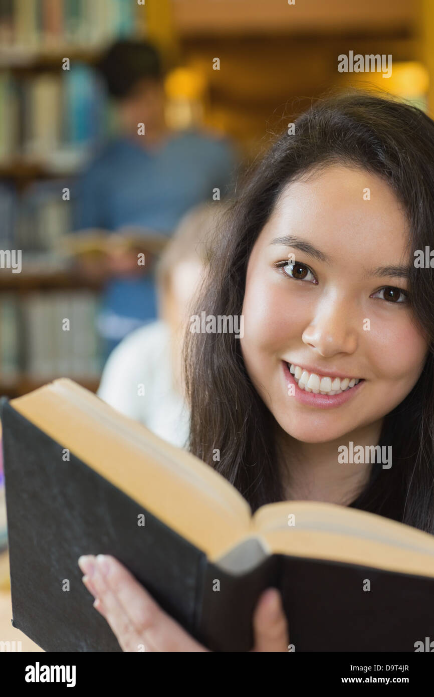 Student in library reading book Stock Photo - Alamy