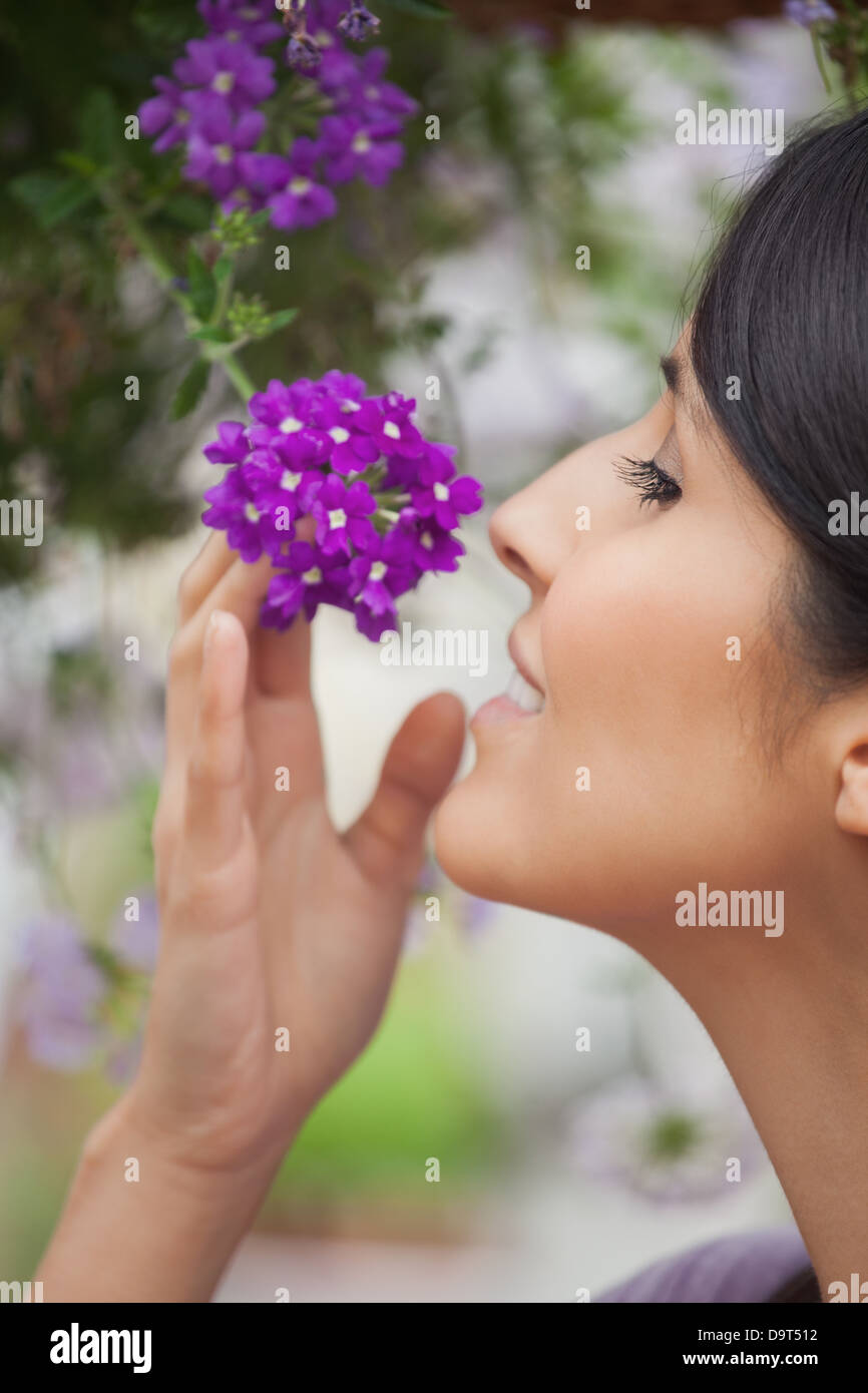 Woman smelling purple flower Stock Photo - Alamy